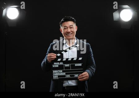 Happy asian actor with clapperboard on stage. Film industry Stock Photo ...