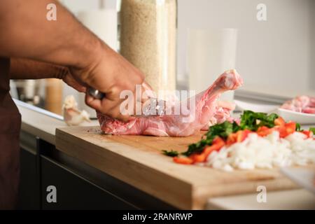 Young black man de-boning chicken to prepare a recipe Stock Photo - Alamy