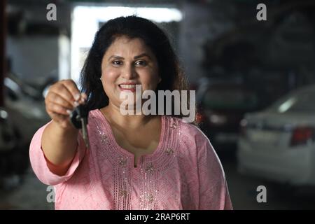 Indian happy customer giving the car keys to the mechanic. Portraying ...