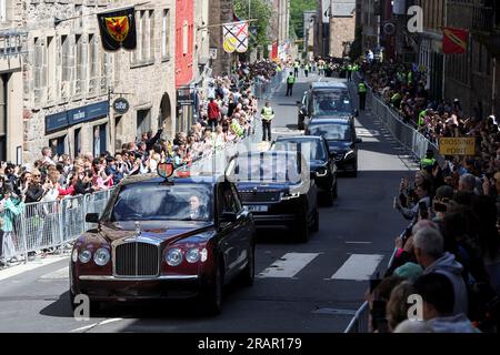The motorcade of Britain's King Charles III drives along the Royal Mile ...