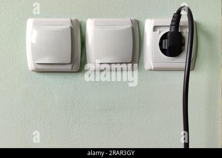 Group of white european electrical outlets with plug on gray concrete ...