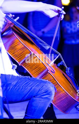 Cello concert with instrument close up. Red vibrant background at rock ...