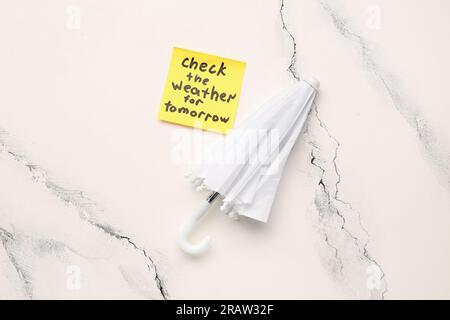 Sticky note with text CHECK THE WEATHER FOR TOMORROW, headphones ...