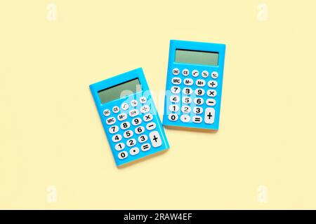 Modern calculators on pale yellow background Stock Photo - Alamy