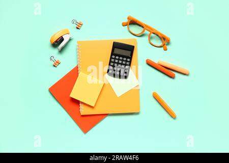 Modern calculator with stationery on turquoise background Stock Photo ...