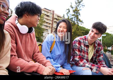 Group of three students laugh a lot sitting outdoors. Teenage gen z ...