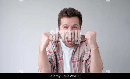 man in awe clenches his fists and shouts yes Stock Photo - Alamy