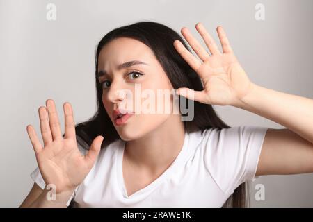Shocked young woman stuck to transparent screen. Internet addiction ...
