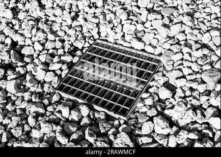 Grated storm drain inlet surrounded by rock for soil erosion control ...