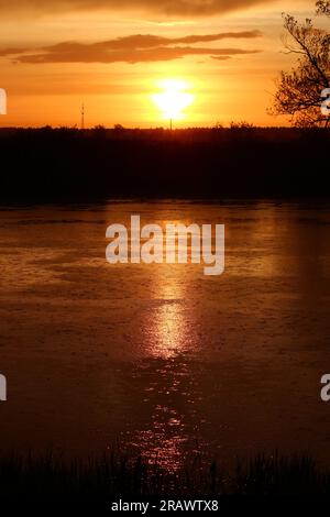Colorful sunset over a pond during rain Stock Photo - Alamy