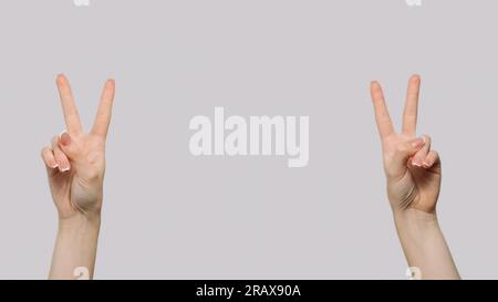 Female hippie showing victory gesture on orange background Stock Photo ...