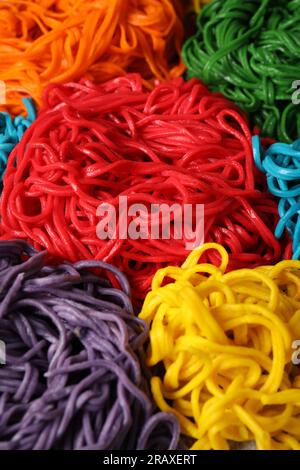 Rolled spaghetti painted with different food colorings as background ...