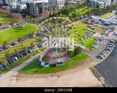 Aerial view of a ferris wheel surrounded by waterfront parkland and car ...