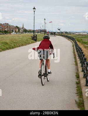 Cyclist on Lytham seafront riding past bench and lamp post Stock Photo ...