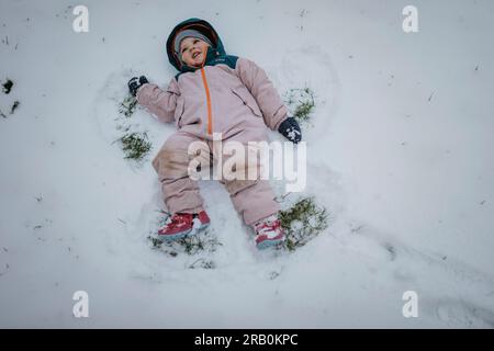 Girl makes snow angel Stock Photo - Alamy
