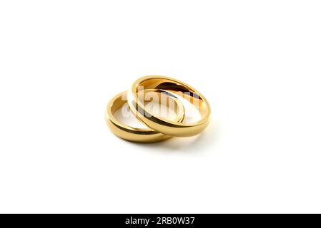 Detail of overlapping gold engagement rings on white isolated ...