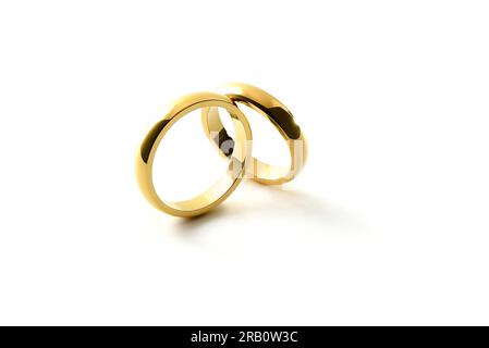 Detail of engagement gold rings standing next to each other on white ...