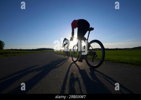 Two young men on racing bikes Stock Photo - Alamy