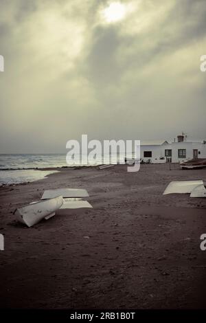 Lonely beach with upside down boat Stock Photo - Alamy