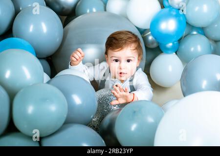 Baby hugging balloons. Kid funny face air balloons. Blue balloons ...