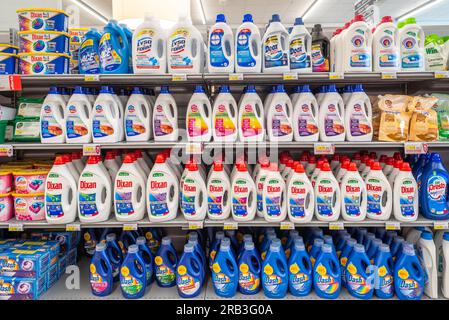 Different types of detergents on shelves in a supermarket. Tide is a laundry detergent ...