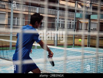 Old man playing Padel Tennis in open-air tennis court Stock Photo - Alamy