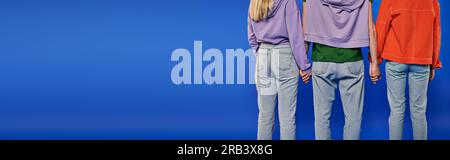 polygamy, back view of polyamory three people, young man and women ...