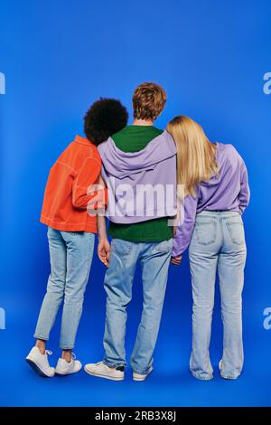 polygamy, back view of polyamory three people, young man and women ...