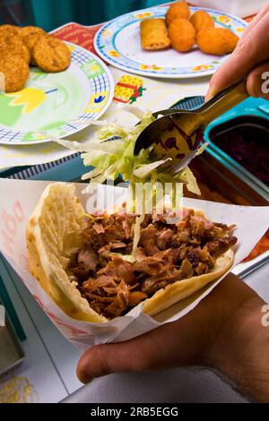 Hands holding a döner kebab in a snack bar FoodCollection Stock Photo ...