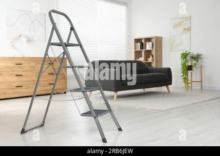 Metal folding ladder in stylish living room Stock Photo - Alamy