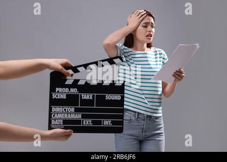 Emotional actress performing role while second assistant camera holding ...