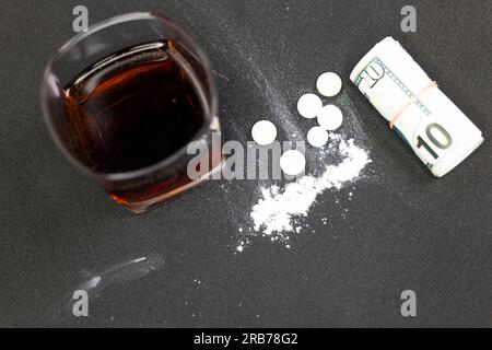 A photo of drugs, tablets, dollar bills, and alcohol in a glass on a ...