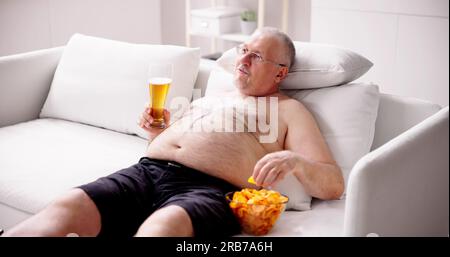 Overeating Junk Food, Drinking Beer And Watching TV Stock Photo - Alamy