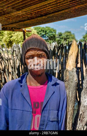 African village man standing in the yard, outdoors kitchen in rural ...