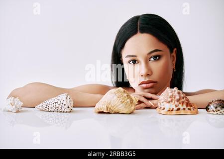 Beautiful african american woman with different seashells on white ...