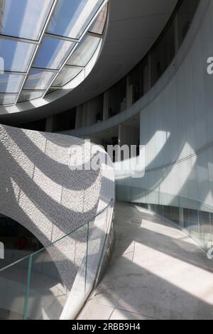 Futuristic atrium with light and shadow, walls clad in white tiles in ...