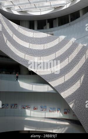 Futuristic atrium with light and shadow, walls clad in white tiles in ...