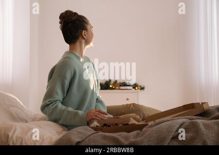 Woman with pizza watching movie via video projector at home Stock Photo ...