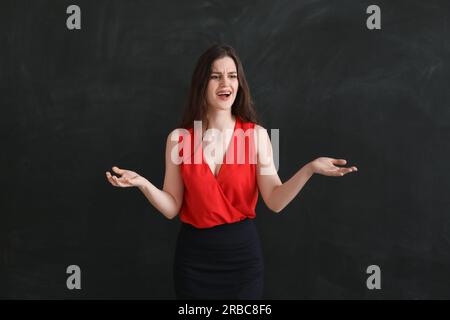 Angry female teacher near blackboard in classroom Stock Photo - Alamy