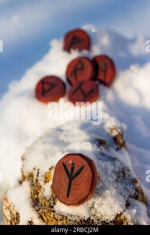 Rune inverted Algiz (Elhaz) carved from wood in the snow Stock Photo ...