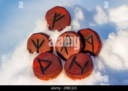 Elder Futhark. Runes of red color carved from wood in the snow Stock ...