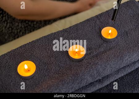 Burning candles and towels on table in spa salon Stock Photo - Alamy