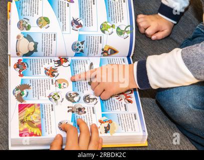 Children reading Pokemon book Stock Photo - Alamy