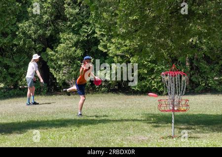 Manitowoc WI Disc golf. A player throwing a concave plastic disc into a ...