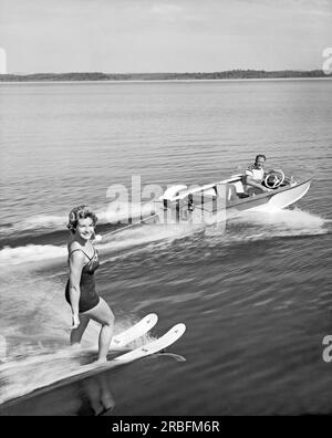 United States: c. 1958. A pretty woman on the beach in a one piece ...