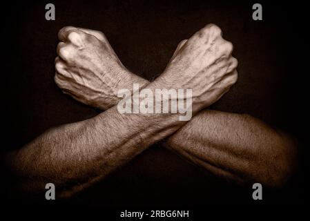 Man's crossed arms as a defense or shield to protect the body. A ...