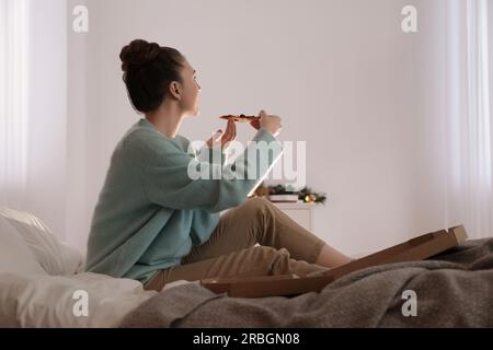 Woman with pizza watching movie via video projector at home Stock Photo ...