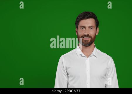 Chroma key compositing. Handsome man smiling against green screen Stock ...