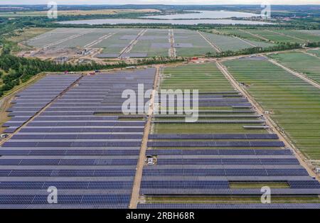 05 July 2023, Saxony, Neukieritzsch: Workers assemble solar panels on ...