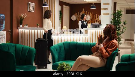 Cheerful smiling professional bellboy in formal attire with baggage ...
